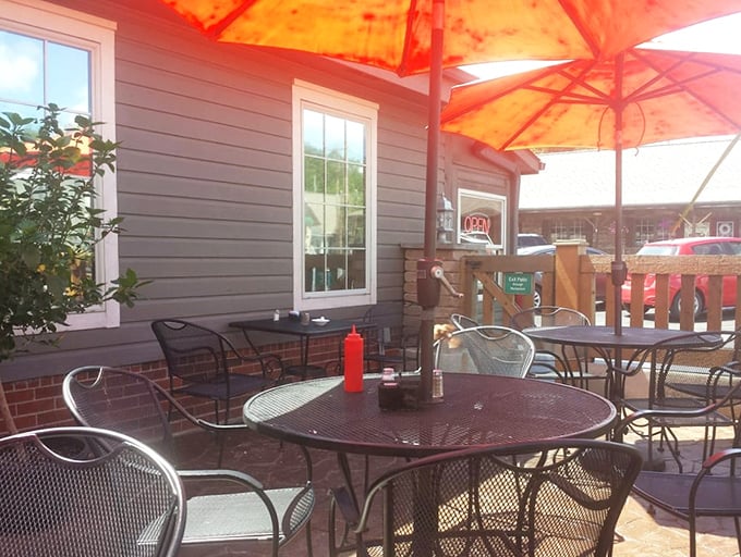 The patio where summer meals taste even better, with umbrellas providing shade for both diners and their comfort food treasures.