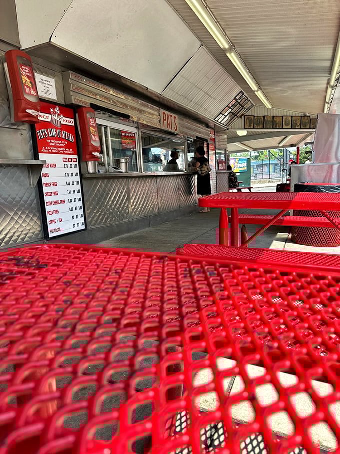 Red tables under open skies—Philadelphia's most democratic dining room. The conversation between strangers here is as good as the food.