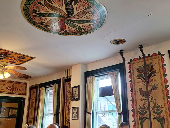 Ceiling medallions and hanging tapestries showcase traditional Pennsylvania Dutch folk art—visual appetizers that feed your eyes while you wait for your meal.