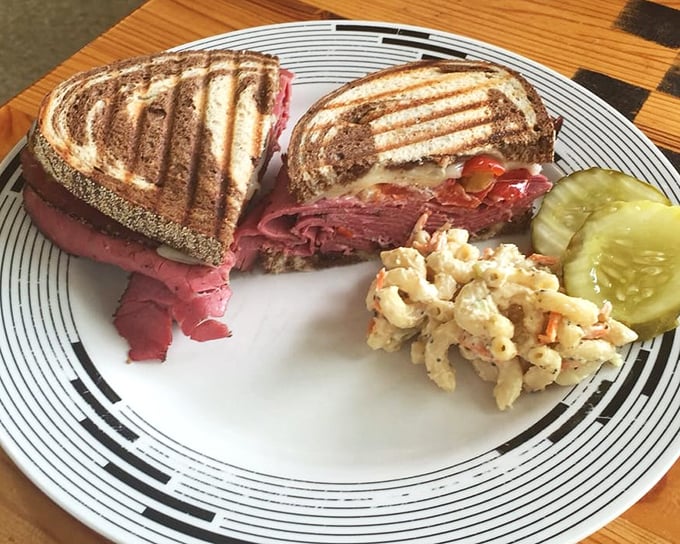 A sandwich with perfect grill marks and a personality to match. That pickle and pasta salad aren't mere sides—they're supporting actors in a delicious drama.