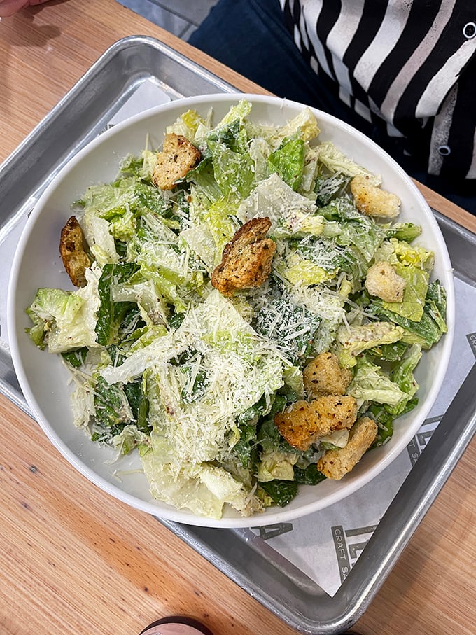 This Caesar salad isn't just a supporting actor – it's ready for its close-up with perfectly dressed greens and house-made croutons.
