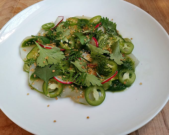 A verdant celebration on a plate – this scallop aguachilé dances with jalapeños and radishes in a symphony of colors that taste as vibrant as they look.