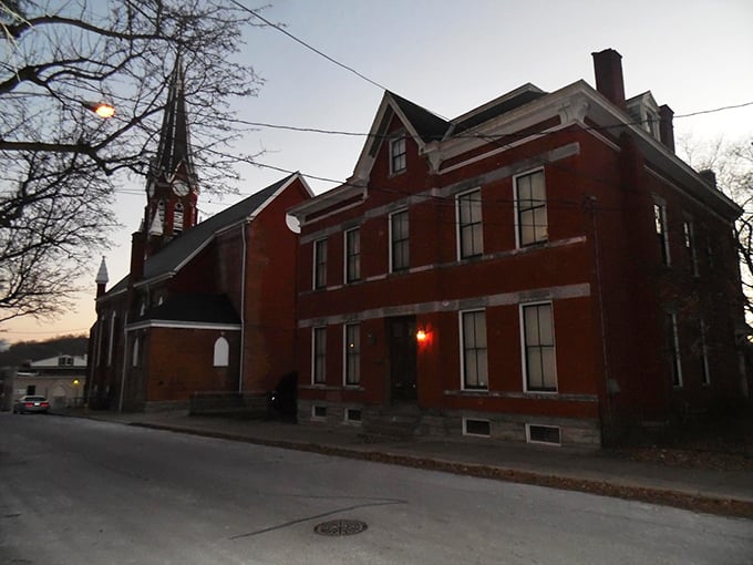 As dusk falls, the rectory's true character emerges. Notice the church spire nearby—keeping watch or keeping something contained?