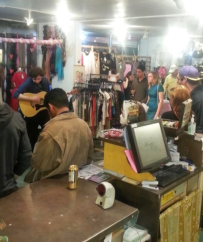 The thrill of the hunt in action—shoppers gathering for what appears to be an impromptu musical performance between bargain discoveries.