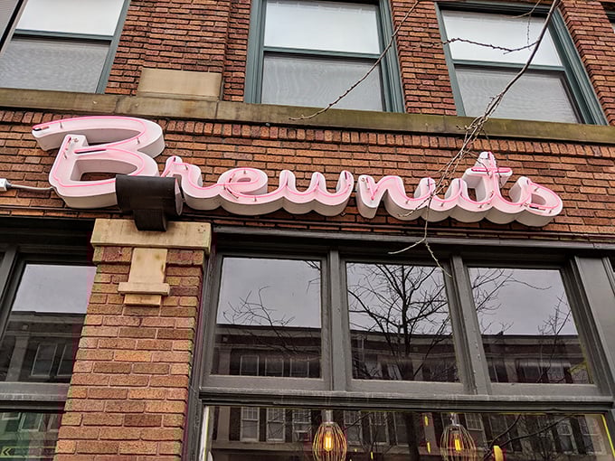 The pink neon "Brewnuts" sign illuminates the brick facade like a sugary North Star guiding hungry travelers home.