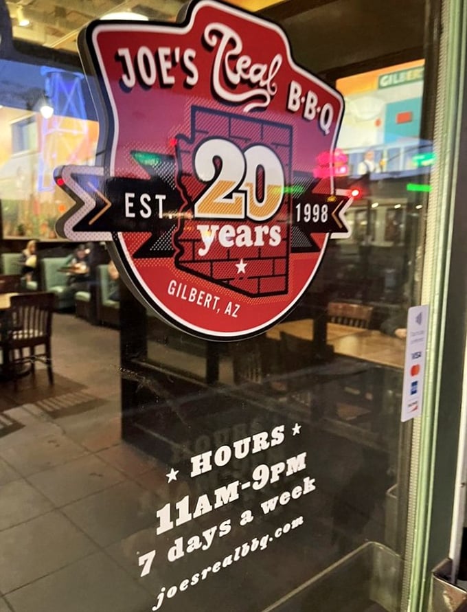 The window sign tells the story of longevity in a business where many flame out—over two decades of smoking meat is a testament to doing things right.