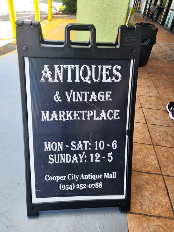 The sidewalk sign announces business hours with vintage flair – an invitation to step away from the digital world and into tactile nostalgia.