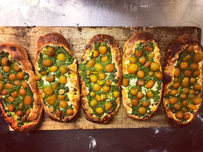 These olive-studded flatbreads look like edible art – the kind of food that makes you pause to take a picture before inevitably devouring it.