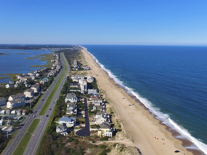 The slender barrier island from above reveals its precarious beauty—ocean on one side, bay on the other, humanity in between.