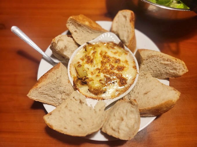 Artichoke dip surrounded by bread soldiers ready for dipping duty. The bubbling cheese top is nature's "Eat Me" sign.