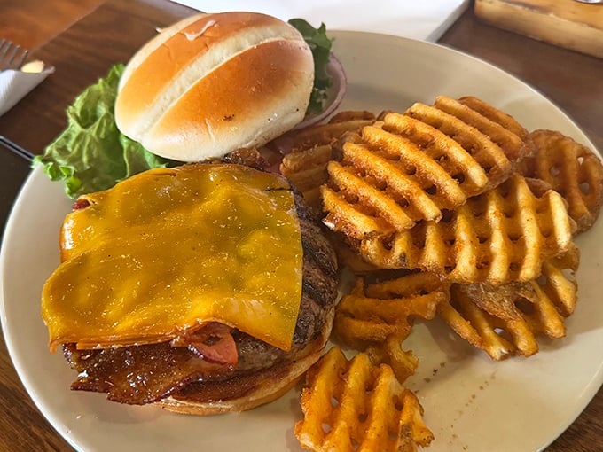 A burger that doesn't just satisfy hunger—it obliterates it. Those waffle fries aren't sidekicks; they're co-conspirators in deliciousness.