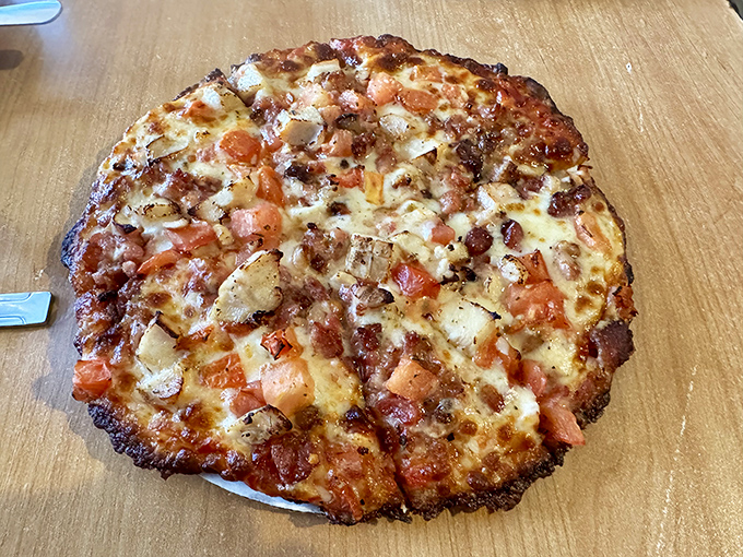 This isn't just any pizza—it's a flavor collaboration where bacon and chicken find their perfect partners in a creamy Alfredo backdrop.