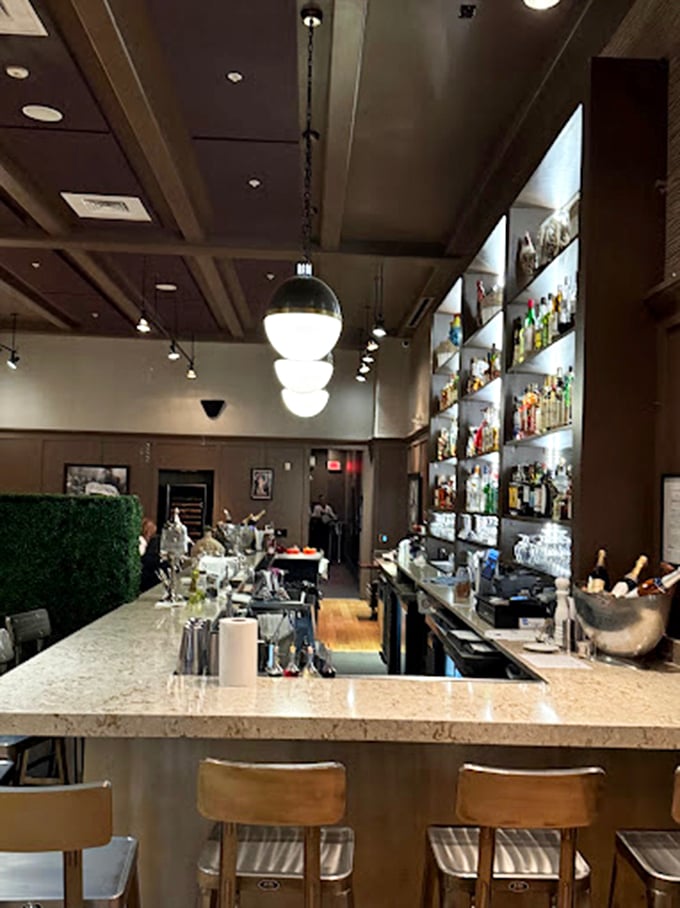 The bar area doesn't just serve drinks—it offers liquid companionship for your culinary journey through France. Those pendant lights add just the right ambiance.
