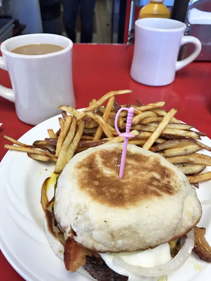 The humble breakfast sandwich elevated to art form—crispy-edged English muffin embracing eggs and meat in a handheld symphony of morning flavors.
