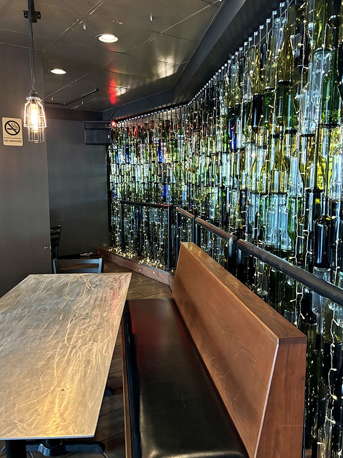 Booth seating backed by an illuminated bottle wall—dinner and a light show in one convenient package.