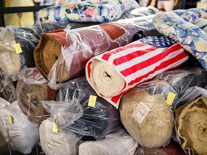Fabric rolls stacked like a textile bakery. That American flag pattern is just waiting to become someone's statement piece at the Fourth of July barbecue.