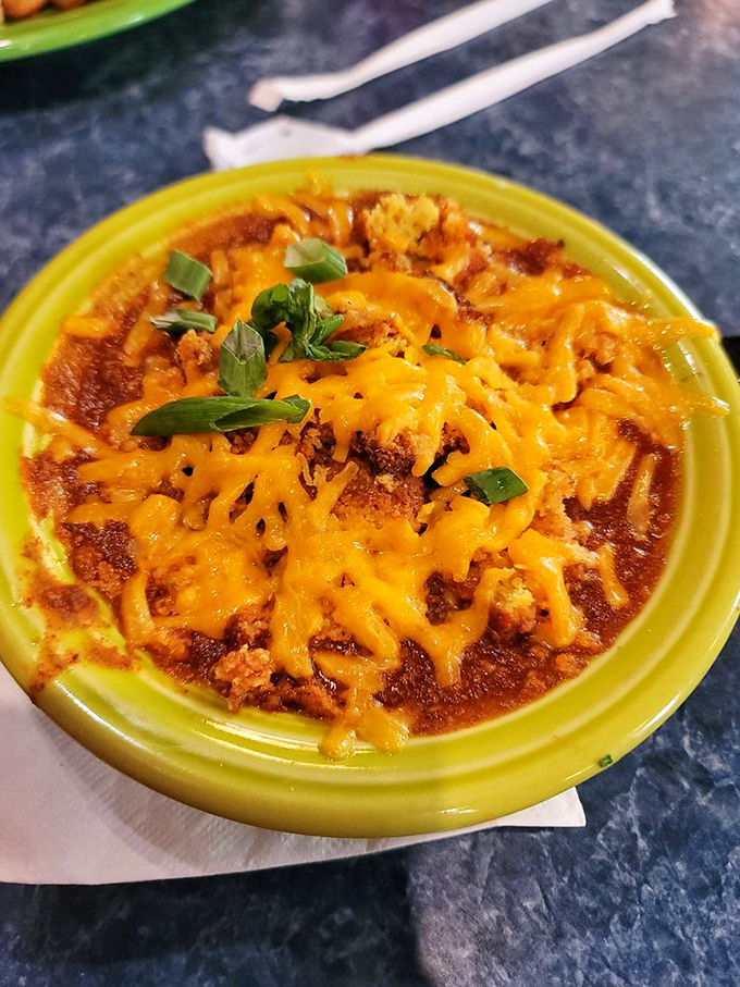 This bowl of chili topped with melted cheddar and green onions isn't just food – it's a warm, spicy hug that says "everything's going to be okay."