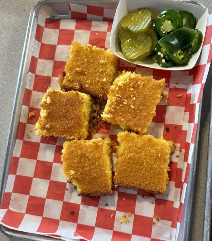 Cornbread squares that achieve the impossible: somehow both crumbly and moist, with jalapeños standing by for those brave enough.