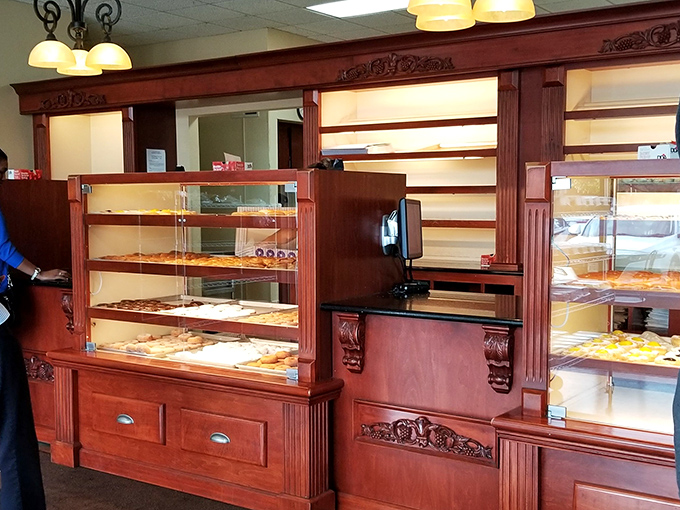 Rich wood cabinetry frames these pastry cases like the masterpieces they contain. Museum-quality displays for everyday indulgences.