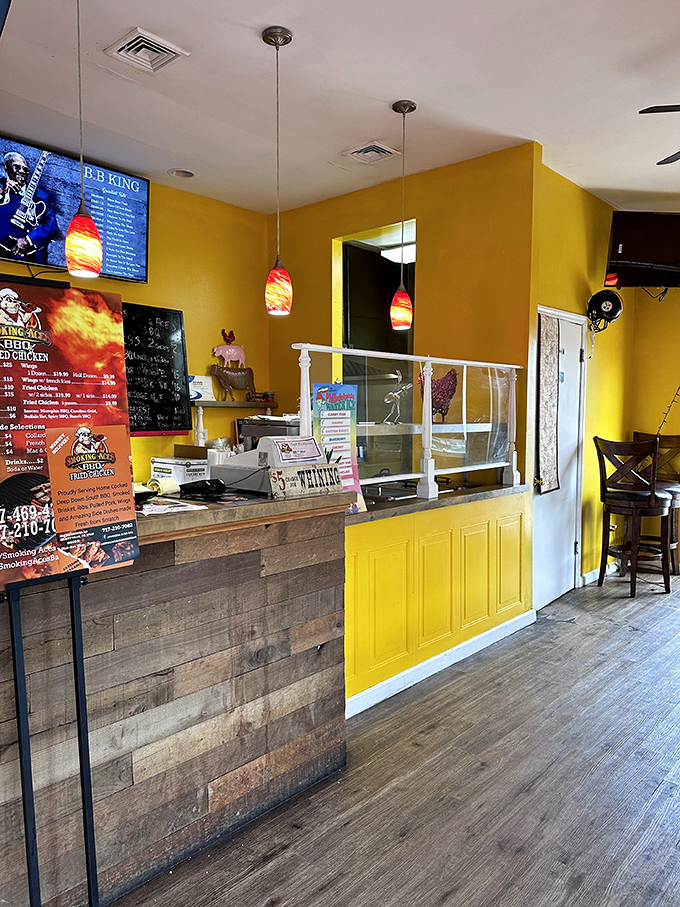 Where barbecue dreams come true—rustic wood paneling meets sunny yellow walls at the ordering counter, with colorful pendant lights adding a touch of whimsy.