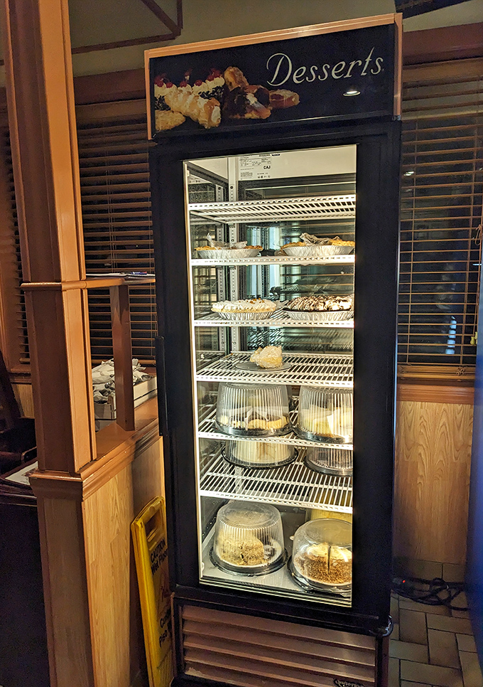 The dessert case—where willpower goes to die a delicious death. Each shelf a different chapter in the story of why pants have elastic waistbands.