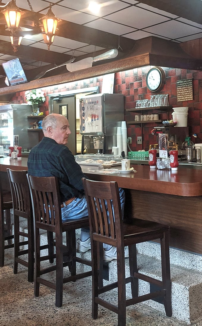 A patron enjoying the timeless ritual of counter dining—where you can watch your breakfast being born right before your eyes.
