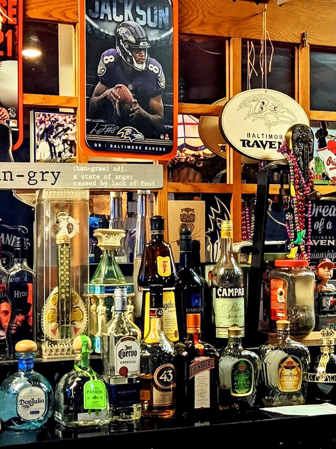 The bar's back wall—a shrine to Baltimore sports and spirits—where Ravens memorabilia watches over your drinking decisions with silent approval.