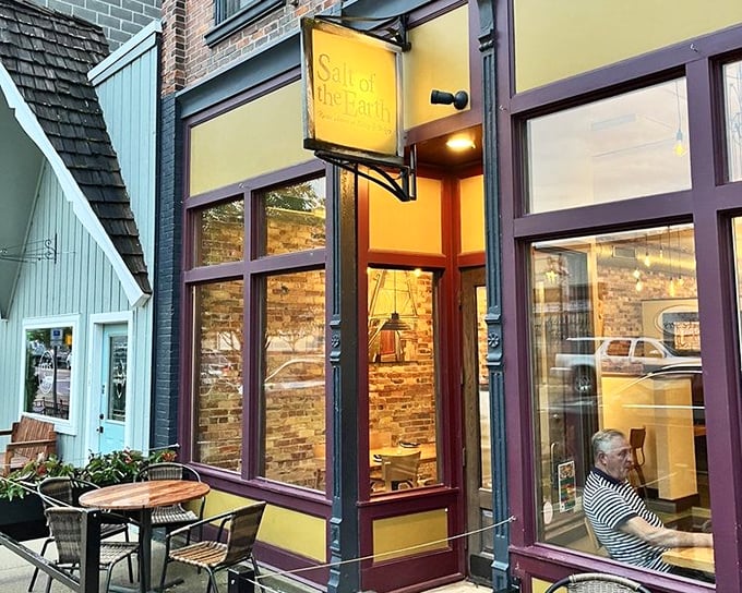 The welcoming storefront with its cheerful yellow sign promises memorable meals inside. Sidewalk seating for those perfect Michigan summer evenings.