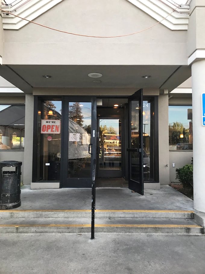 The entrance beckons with a simple "OPEN" sign – two syllables that promise culinary happiness awaits just beyond those doors.