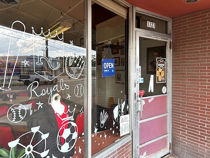 The entrance to barbecue paradise—where Kansas City sports pride meets the promise of smoky delights just beyond that unassuming door.
