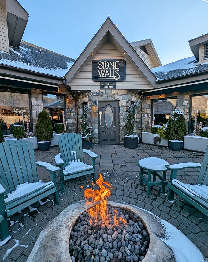 Winter transforms the entrance into a scene from a holiday movie—fire dancing against snow-dusted chairs, inviting you into the warmth.