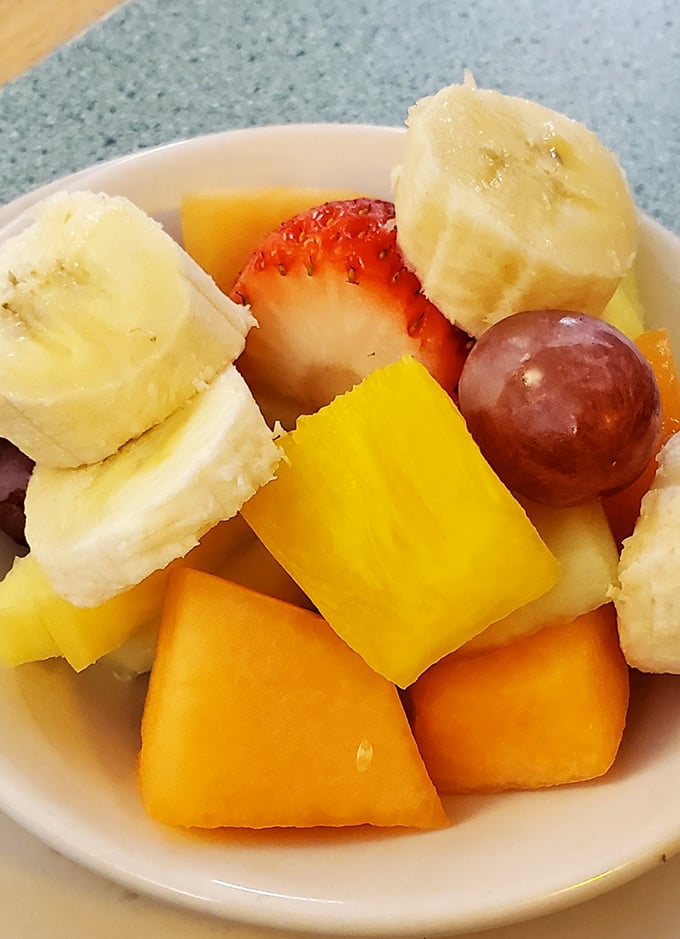 A fruit cup that actually looks like someone cared – fresh chunks of melon, banana, and berries that aren't just an afterthought.