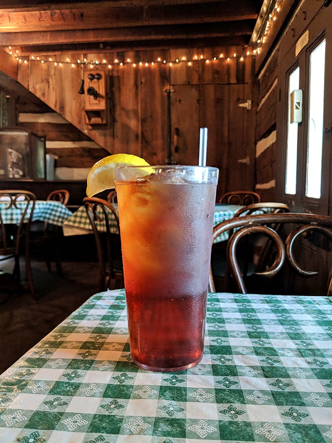 An iced tea with lemon in a rustic setting—the quintessential Midwestern refreshment that somehow tastes better against the backdrop of wooden walls and checkered tablecloths.