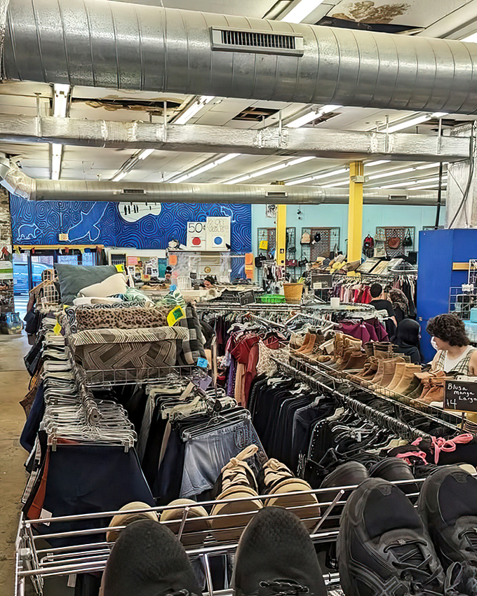 The wide-angle view reveals the true scale of this thrifter's paradise—racks upon racks of possibilities under exposed ductwork and bright lights.