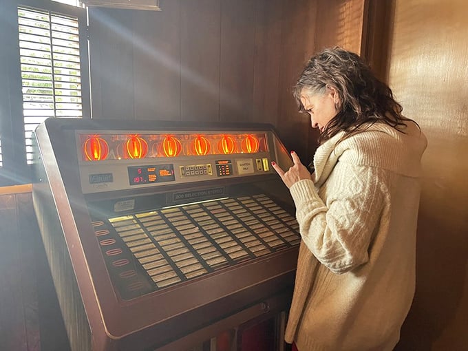 The vintage jukebox stands ready to provide the soundtrack to your meal – a musical time machine that pairs perfectly with comfort food.