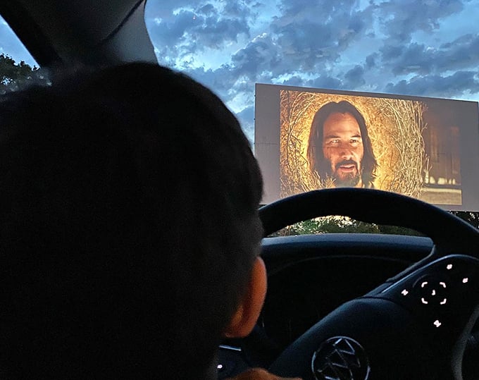 Keanu Reeves commands the massive screen as a viewer watches from behind the wheel—the ultimate private theater with the best seat in the house.