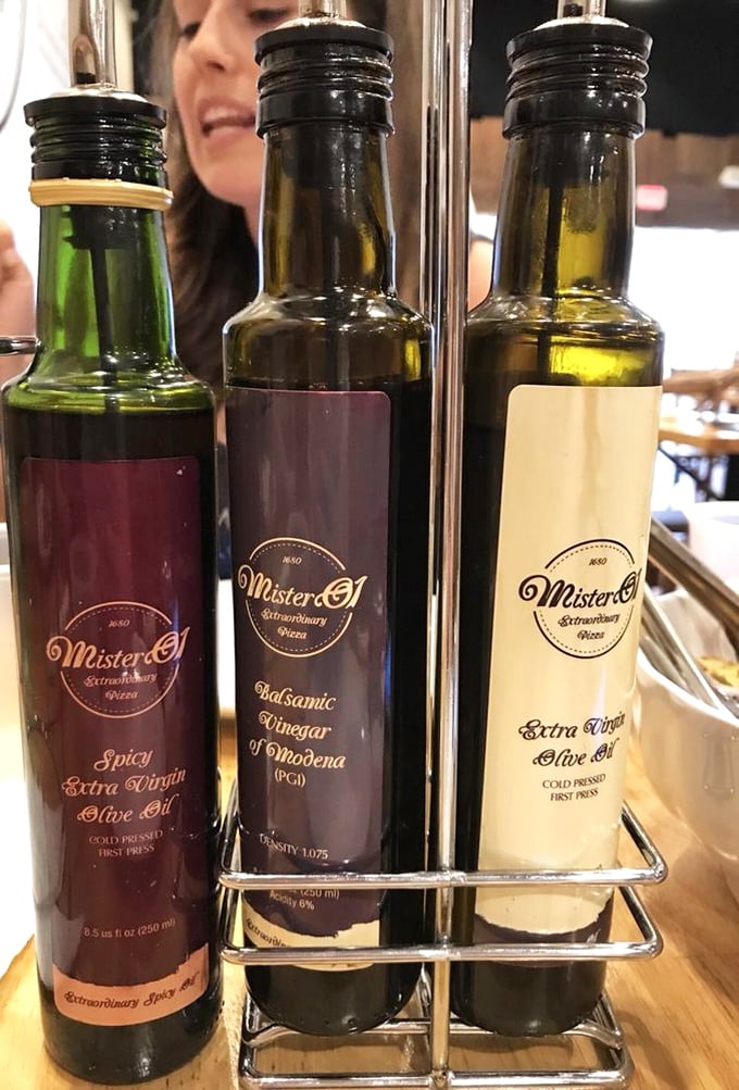 These aren't just condiments—they're liquid gold. The holy trinity of oils and vinegar that transforms good bread into an out-of-body experience.