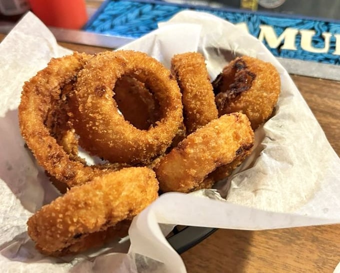 Onion rings with the perfect crunch-to-softness ratio – the unsung heroes of the appetizer world, nestled in their paper-lined basket.