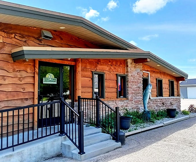 The entrance says "Yes, we're serious about our trout" with rustic wood siding and a fish sculpture standing guard like a delicious sentinel.