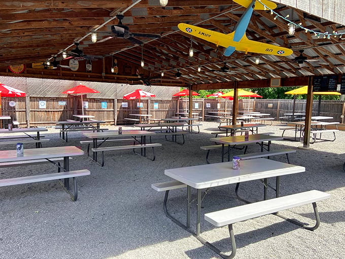 Covered outdoor dining with string lights and picnic tables – because sometimes BBQ tastes even better with a gentle breeze and the sound of laughter.