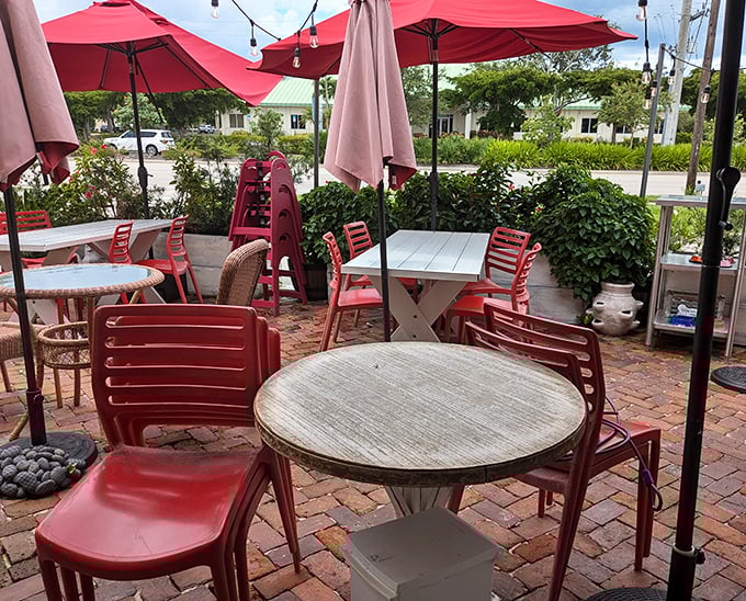 The outdoor seating area—where Florida's perfect weather meets The Rooster's perfect food. Those red chairs have witnessed countless food epiphanies.