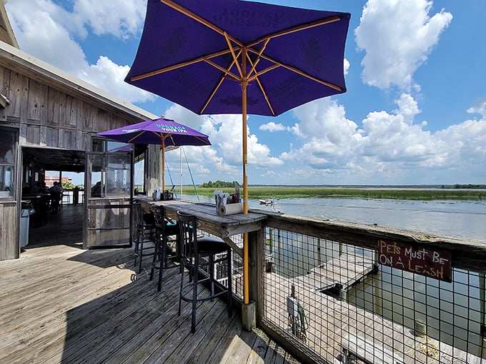 Purple umbrellas shade outdoor seating where the line between restaurant and waterfront blurs – dining with your toes practically in the tide.