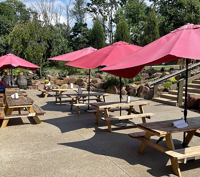 Outdoor seating under cherry-red umbrellas – nature's dining room with shade management. Pennsylvania summers were made for this.