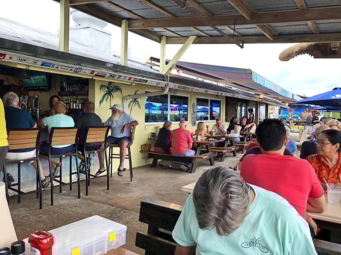 The outdoor seating area where cold beers meet warm conversations, all under the gentle protection of a Florida sky that knows how to put on a show.