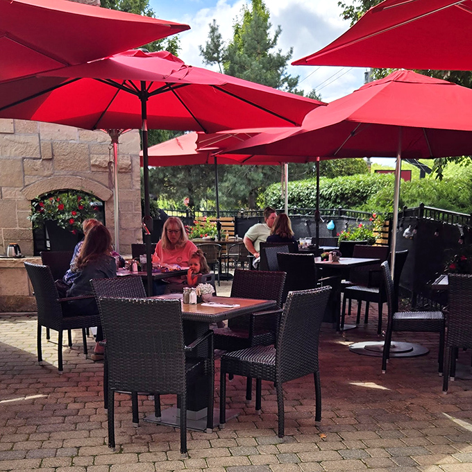 Outdoor dining under crimson umbrellas – where breakfast meets fresh air in a patio setting that makes every meal feel like a mini-vacation.