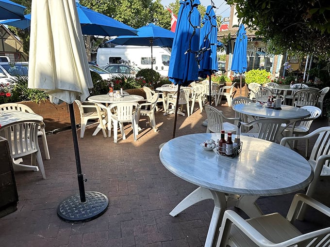 The outdoor seating area awaits the morning rush, those white tables and blue umbrellas promising al fresco dining with a side of people-watching.