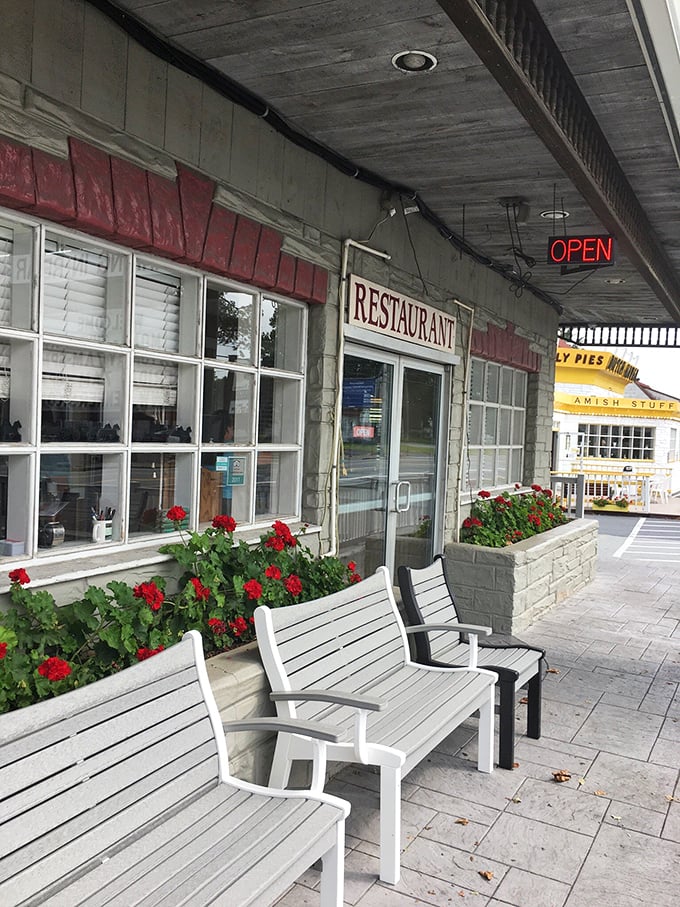 Outside seating where red geraniums stand guard, ensuring your pre-meal wait is as pleasant as the feast to come.