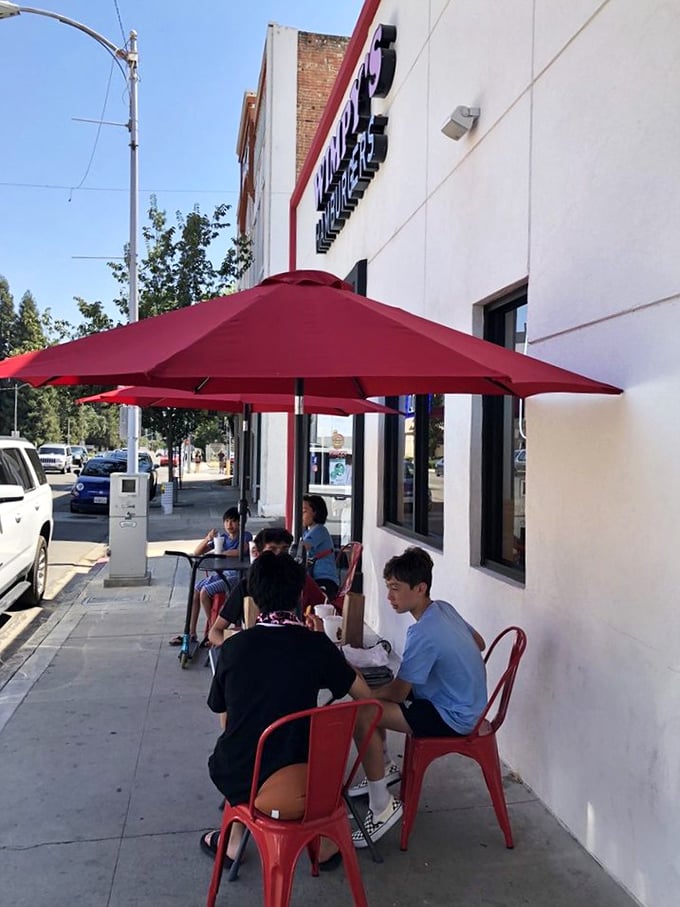 Outdoor seating that turns sidewalk dining into a community experience – complete with those signature red chairs and California sunshine.
