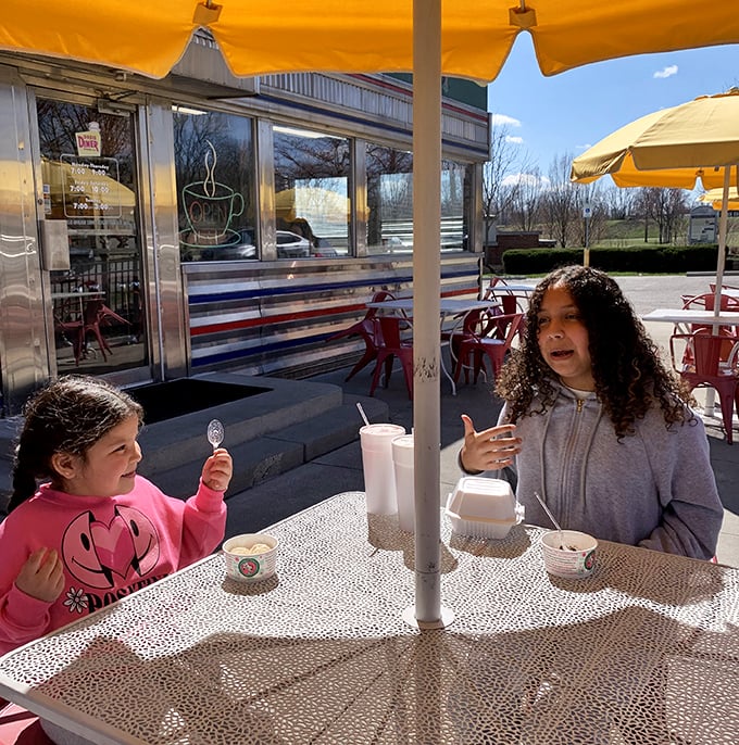 Outdoor dining under yellow umbrellas—where milkshakes taste better with sunshine and conversations come with a side of fresh air.