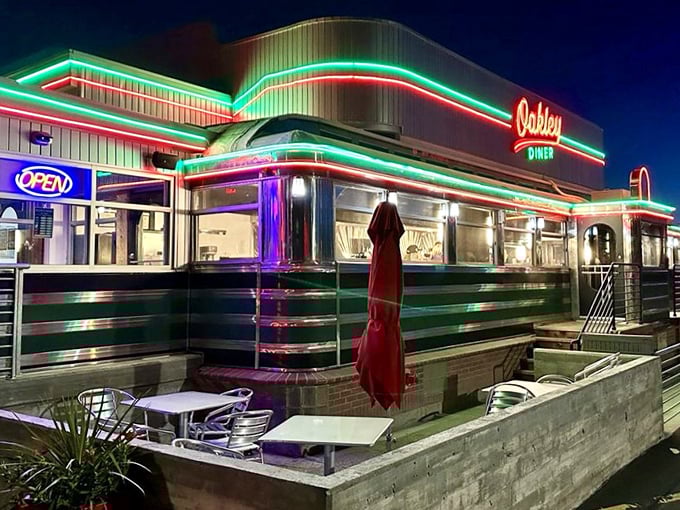 As night falls, the diner transforms into a neon-lit beacon of hospitality, glowing with the promise of late-night comfort and conversation.